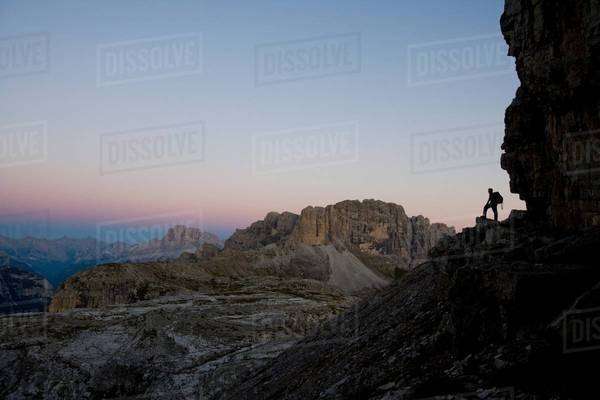 Man standing at flank of a mountain - Royalty-free Stock Photo | Dissolve