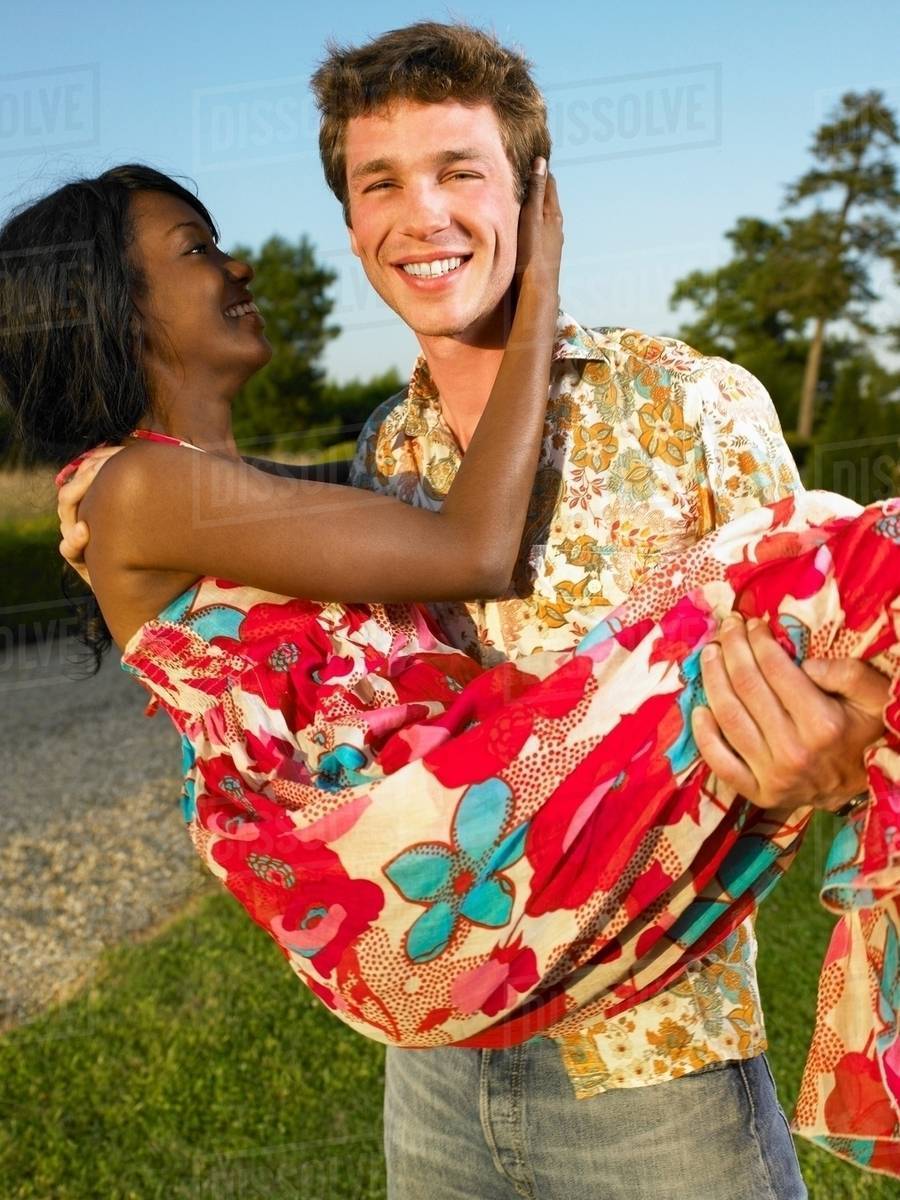 Man carrying woman at sunset - Stock Photo - Dissolve