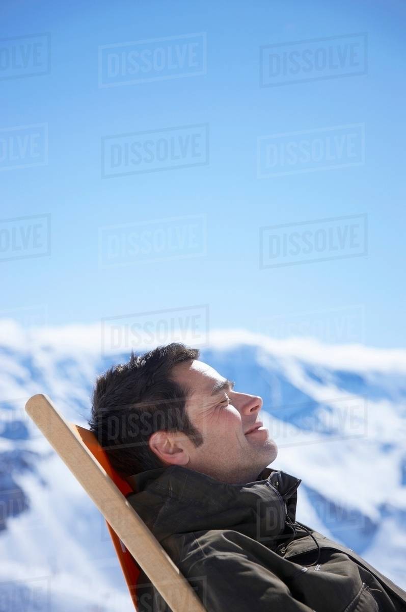 Man reclining in deck chair - Stock Photo - Dissolve
