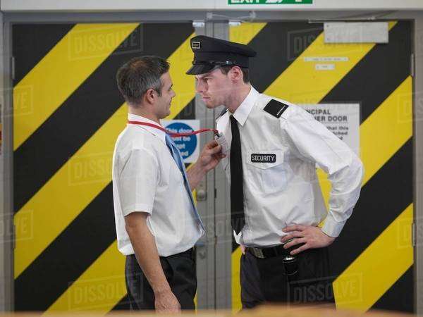Security guard checking security tag - Stock Photo - Dissolve