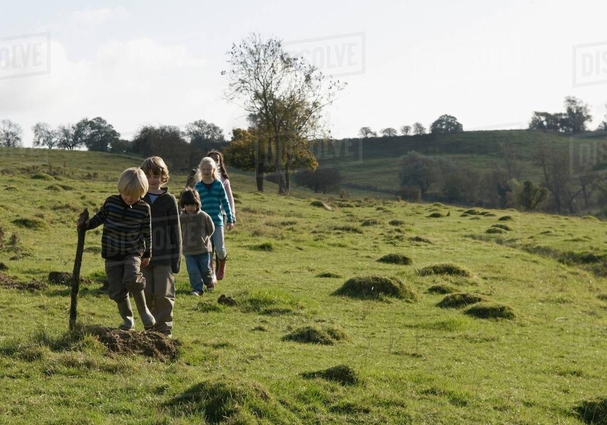 Children walking in field - Royalty-free Stock Photo | Dissolve