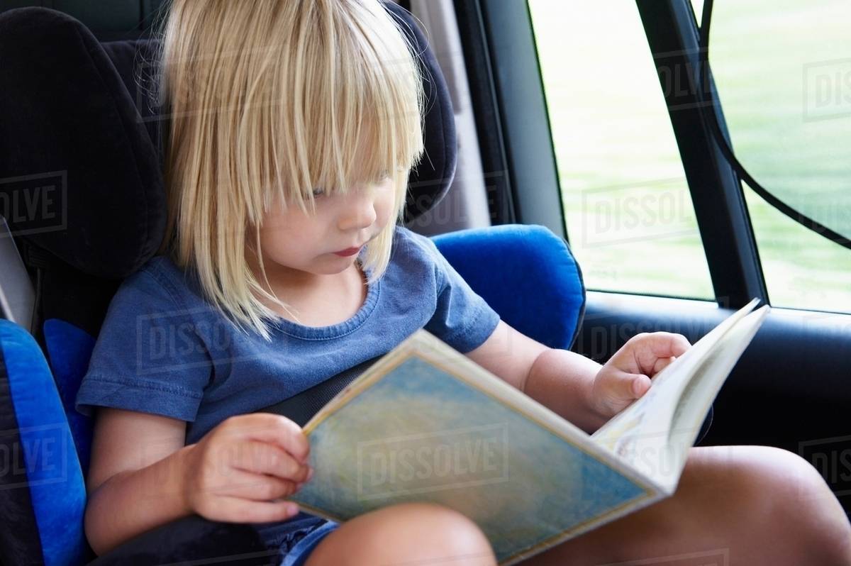 Girl reading in the car - Stock Photo - Dissolve