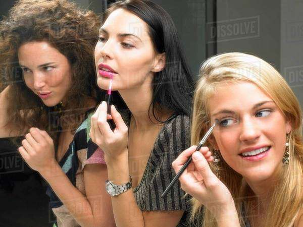 Girls applying makeup - Stock Photo - Dissolve