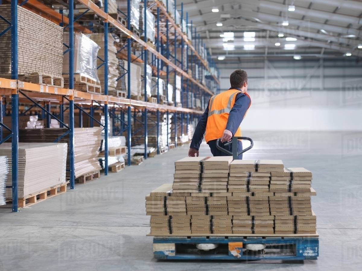 Worker Transporting Load In Warehouse - Stock Photo - Dissolve