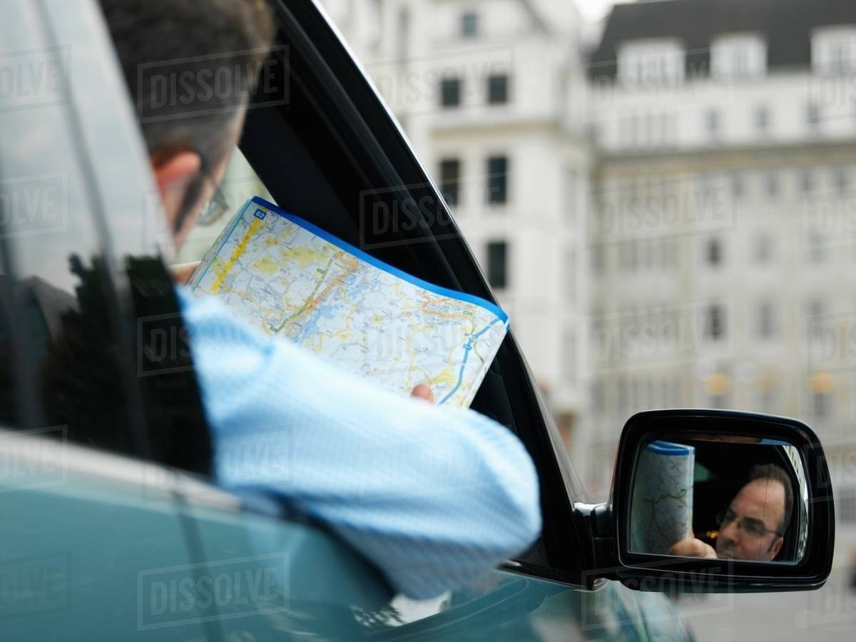 Businessman map reading in car - Royalty-free Stock Photo | Dissolve