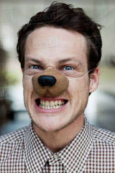 Man with toy dog nose snarling - Royalty-free Stock Photo | Dissolve