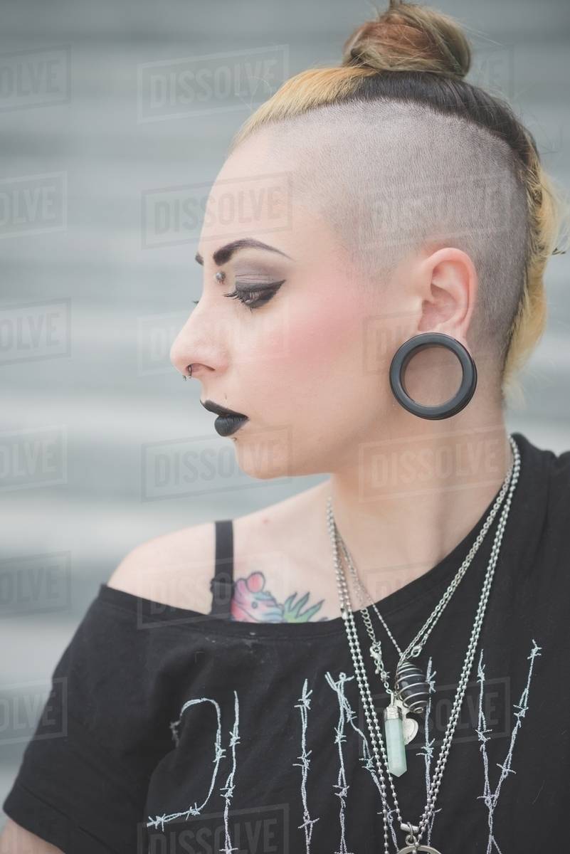 Portrait of young female punk with piercings and shaved head - Royalty ...