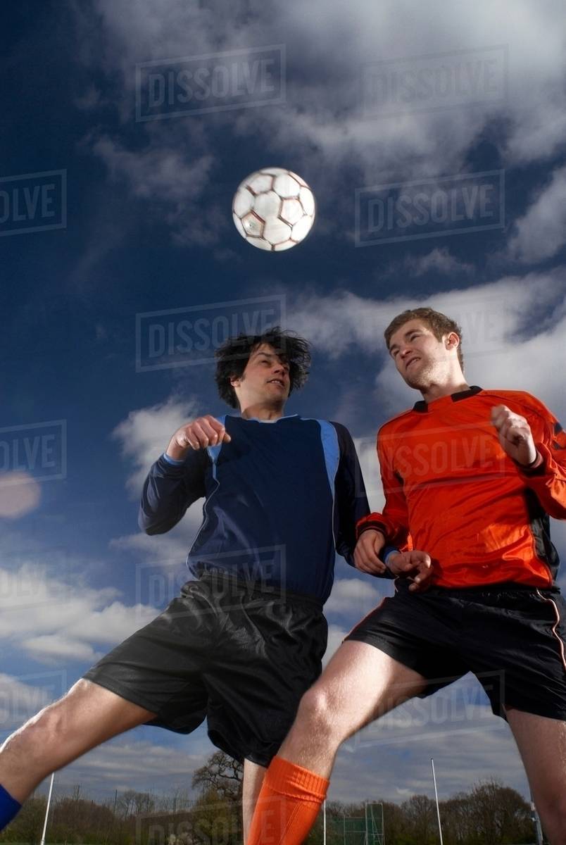 Two footballers jumping for football - Royalty-free Stock Photo | Dissolve