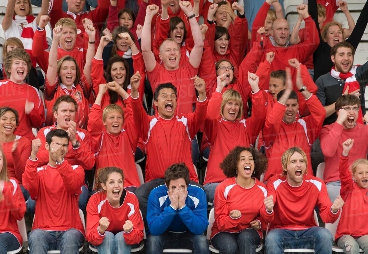 Fan amongst rivals at football match - Stock Photo - Dissolve