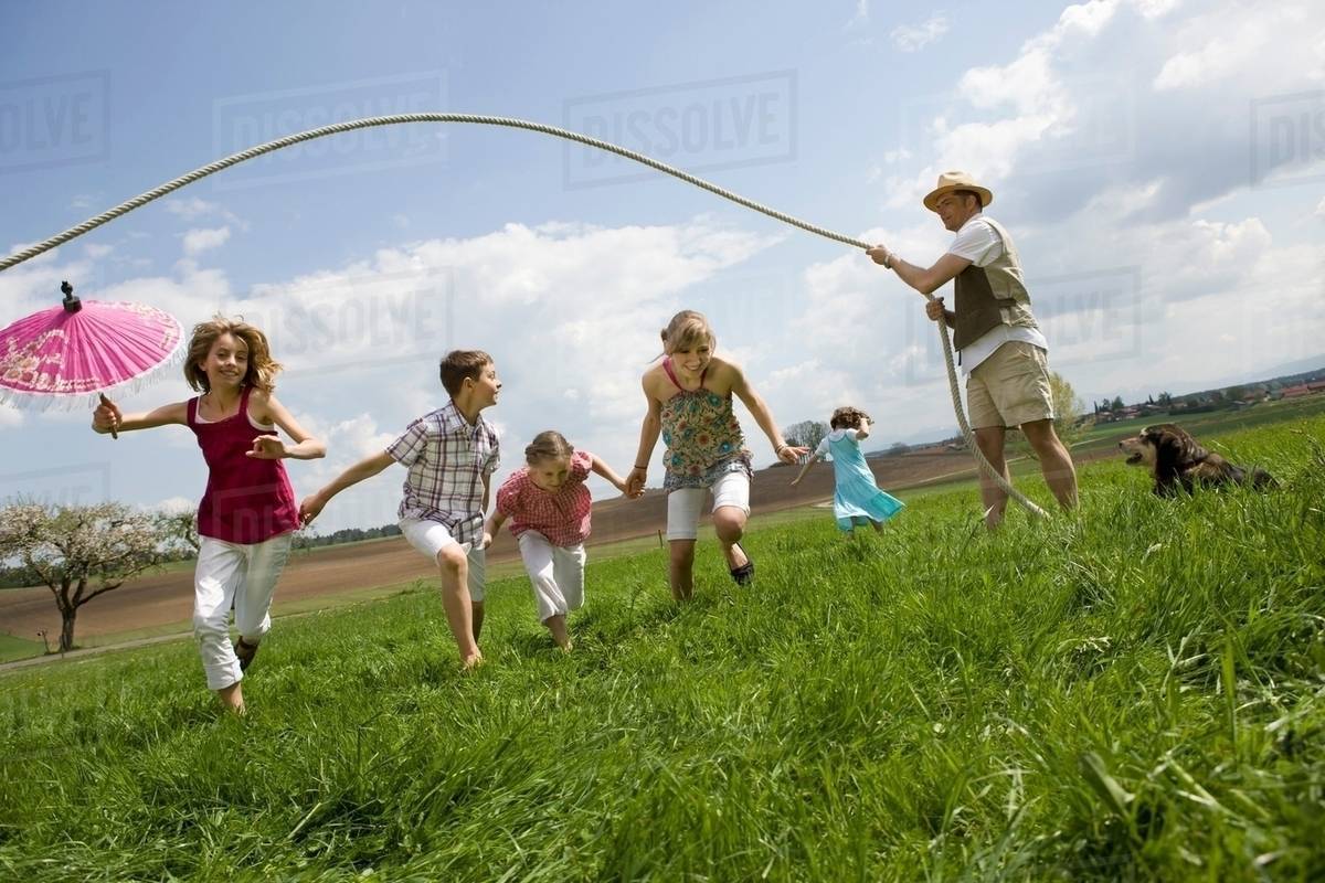 Happy family jump roping in countryside - Royalty-free Stock Photo ...