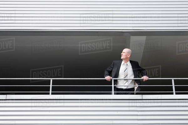 Man leaning out observing - Stock Photo - Dissolve
