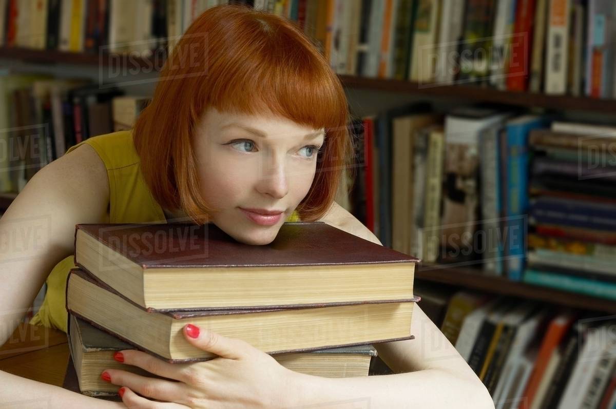 Woman leaning on pile of books - Stock Photo - Dissolve