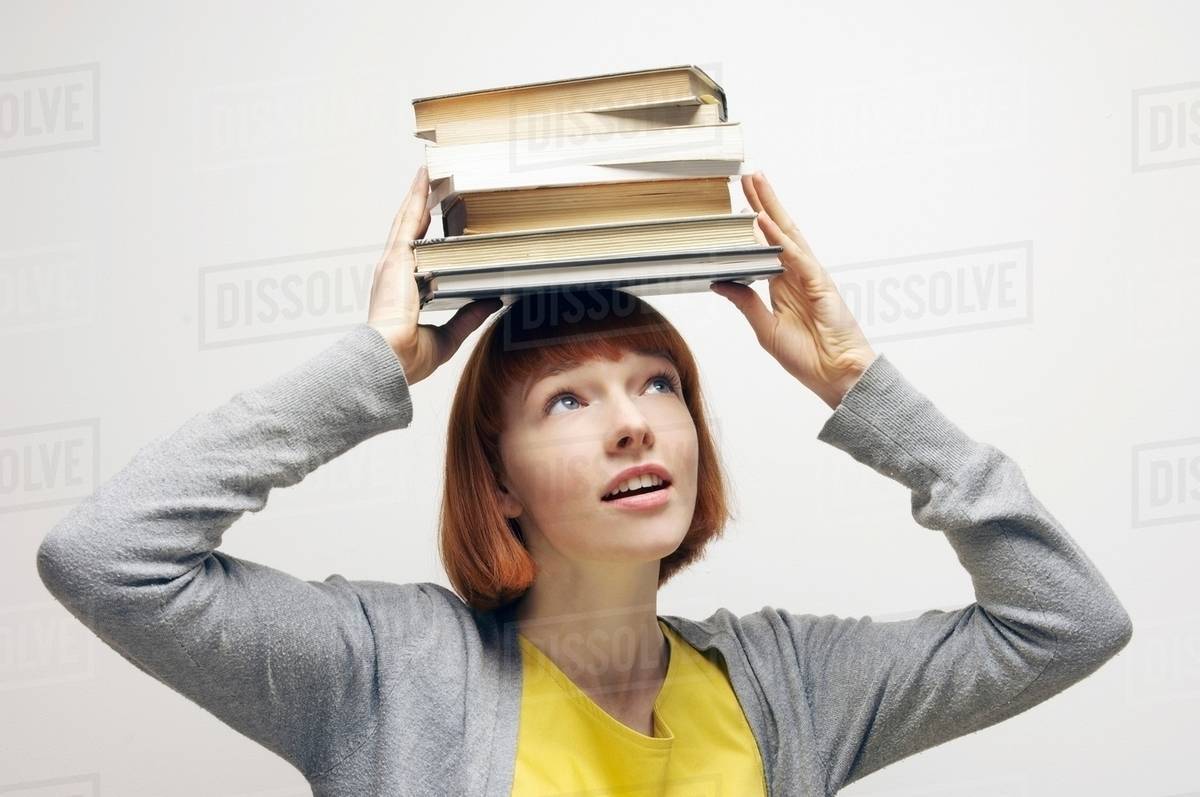 Woman balancing books on head - Royalty-free Stock Photo | Dissolve