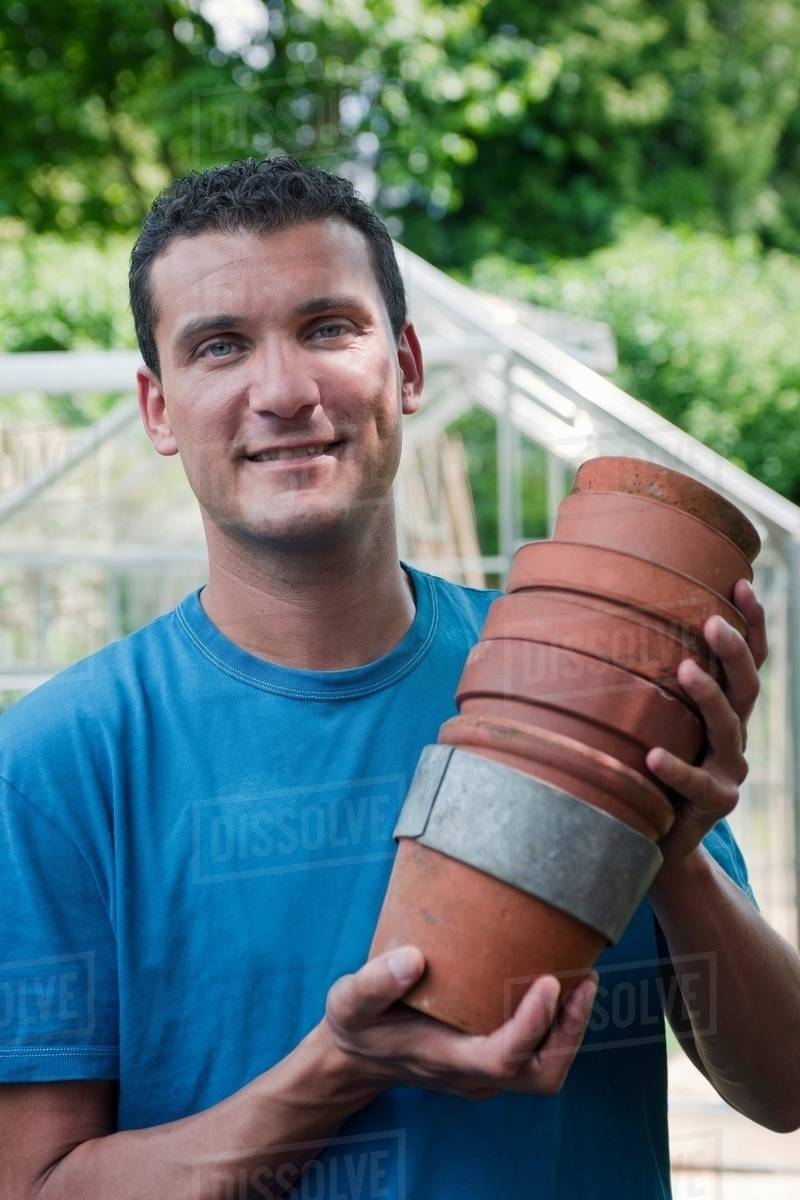 Man in garden with plant pots - Stock Photo - Dissolve