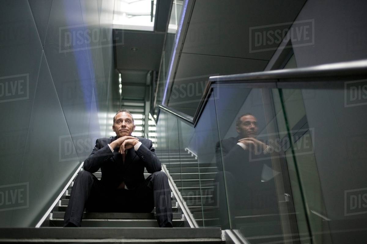 Man sitting on stair steps - Royalty-free Stock Photo | Dissolve