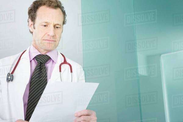 A doctor reading some notes - Royalty-free Stock Photo | Dissolve