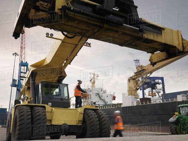 Port Workers With Container Grab - Stock Photo - Dissolve