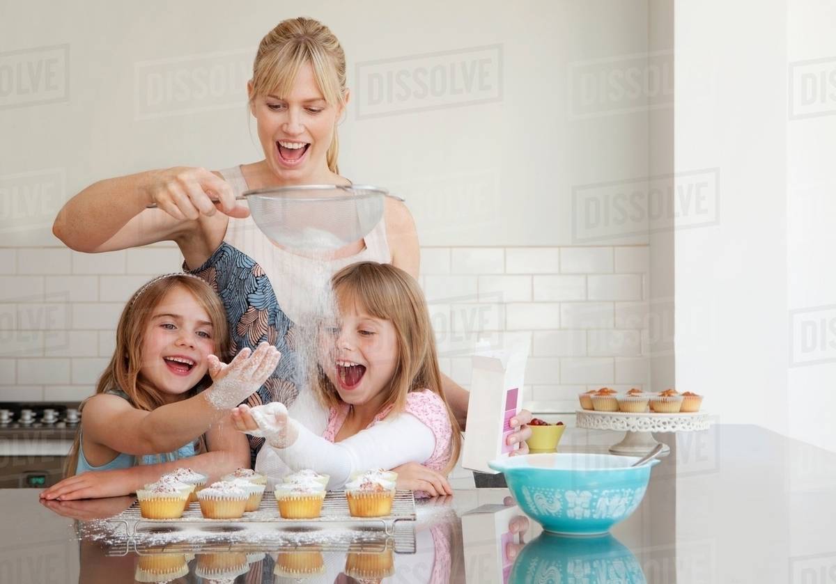 Two girls and a mum baking - Stock Photo - Dissolve