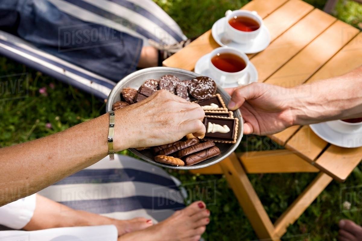 Man offering biscuits to senior woman - Royalty-free Stock Photo | Dissolve