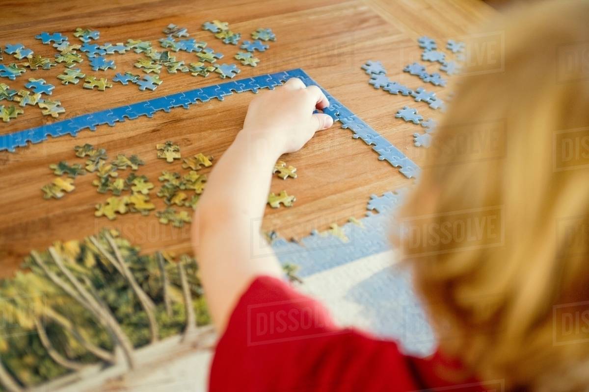 Portrait of a child doing a puzzle - Stock Photo - Dissolve