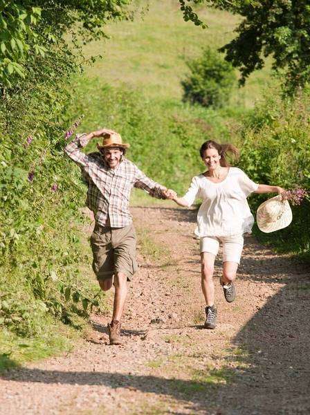 Man and woman running down country lane - Stock Photo - Dissolve
