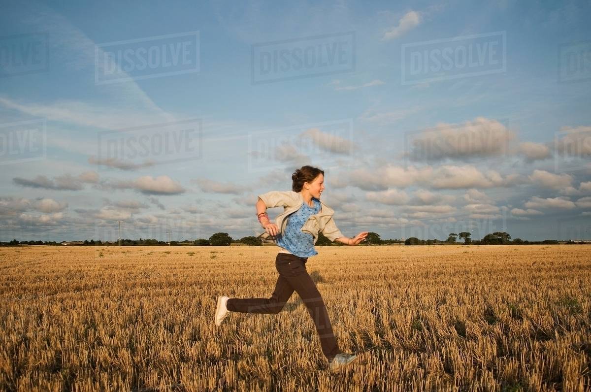 A young girl running through a field - Royalty-free Stock Photo | Dissolve
