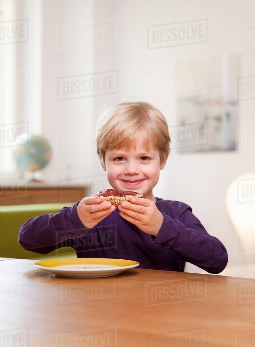 Boy eating bread roll - Stock Photo - Dissolve