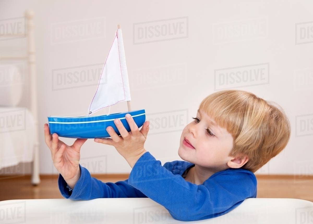 Boy with toy boat - Stock Photo - Dissolve