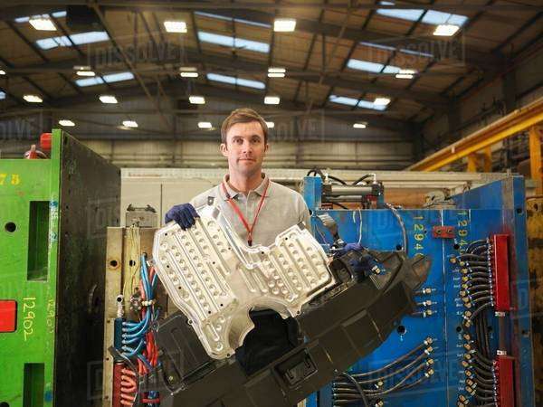 Factory Worker Holding Machine Part - Stock Photo - Dissolve