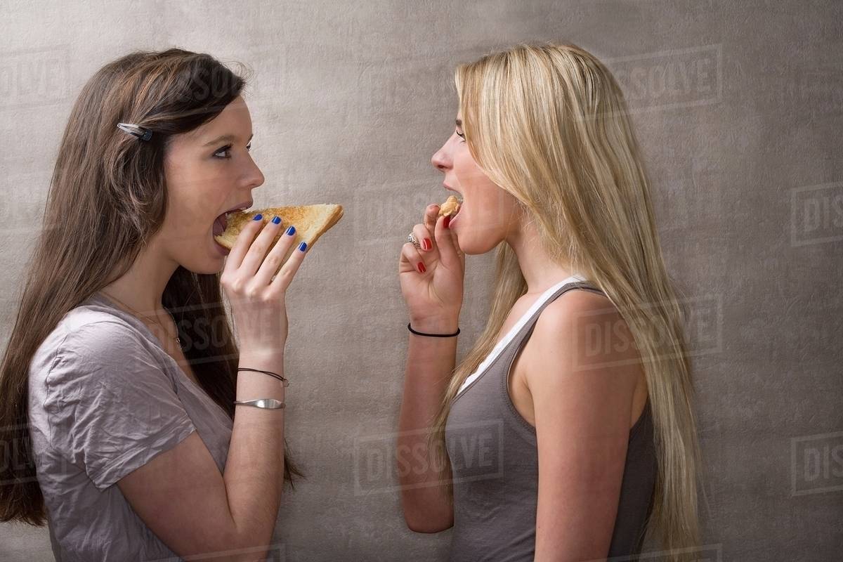 Teen girls eat sandwiches - Royalty-free Stock Photo | Dissolve