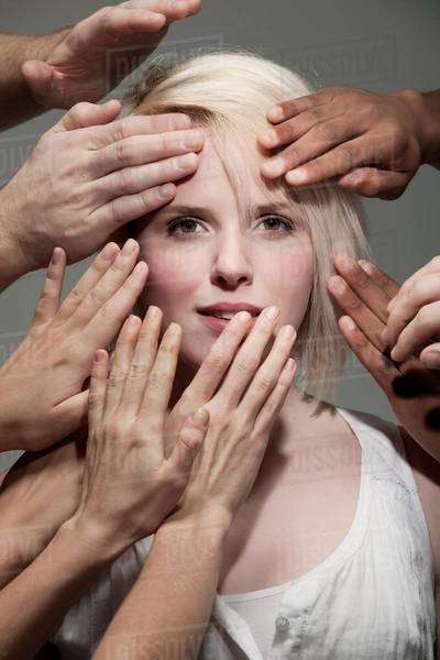 Woman being touched by many hands - Royalty-free Stock Photo | Dissolve
