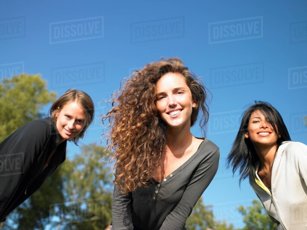 Women looking into the camera, smiling - Stock Photo - Dissolve