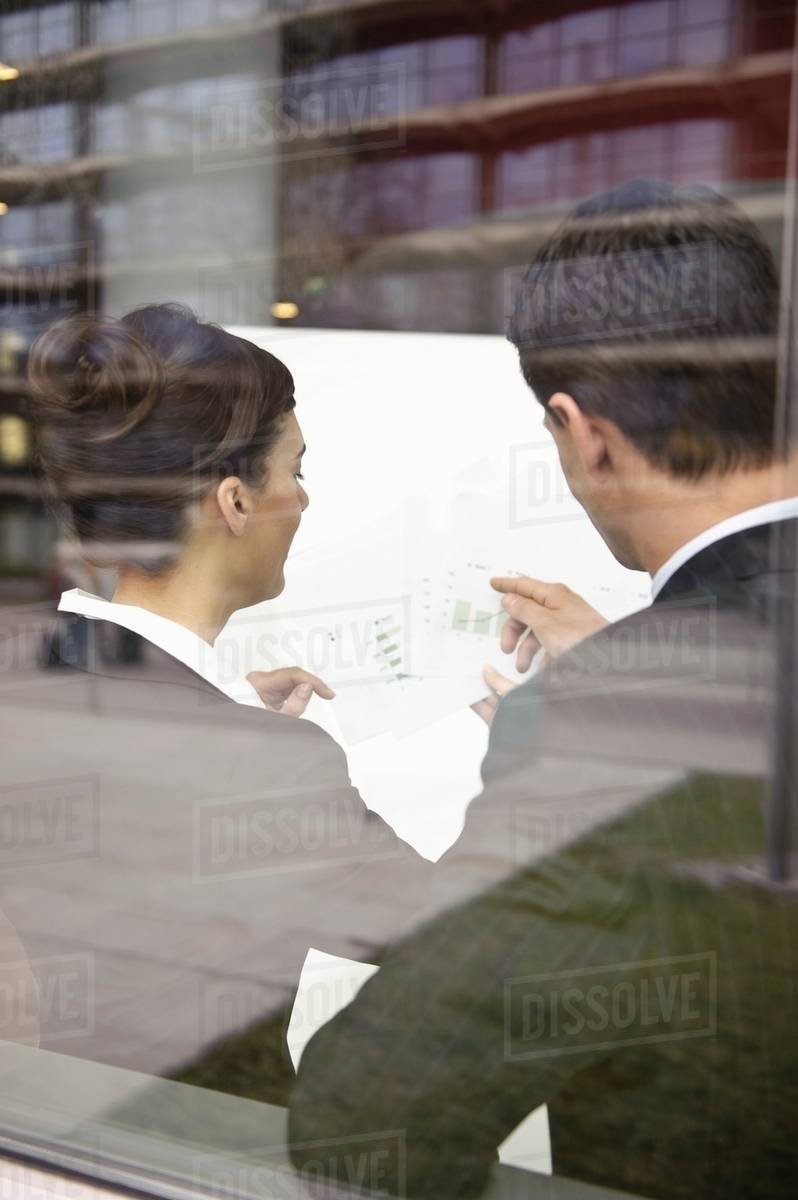 Business people looking at paperwork - Stock Photo - Dissolve