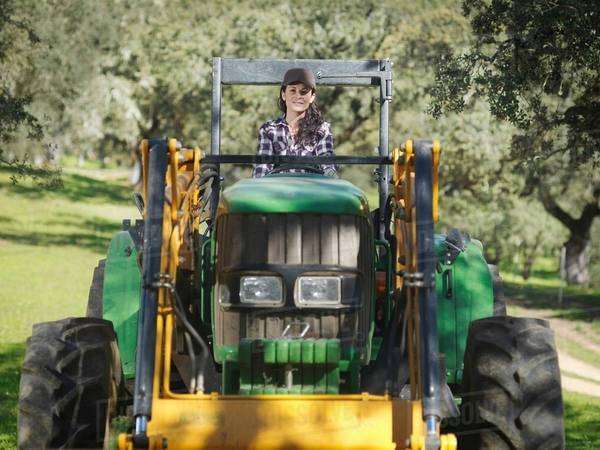 Woman on tractor - Stock Photo - Dissolve