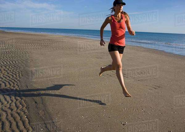 Woman jogging on the beach - Stock Photo - Dissolve