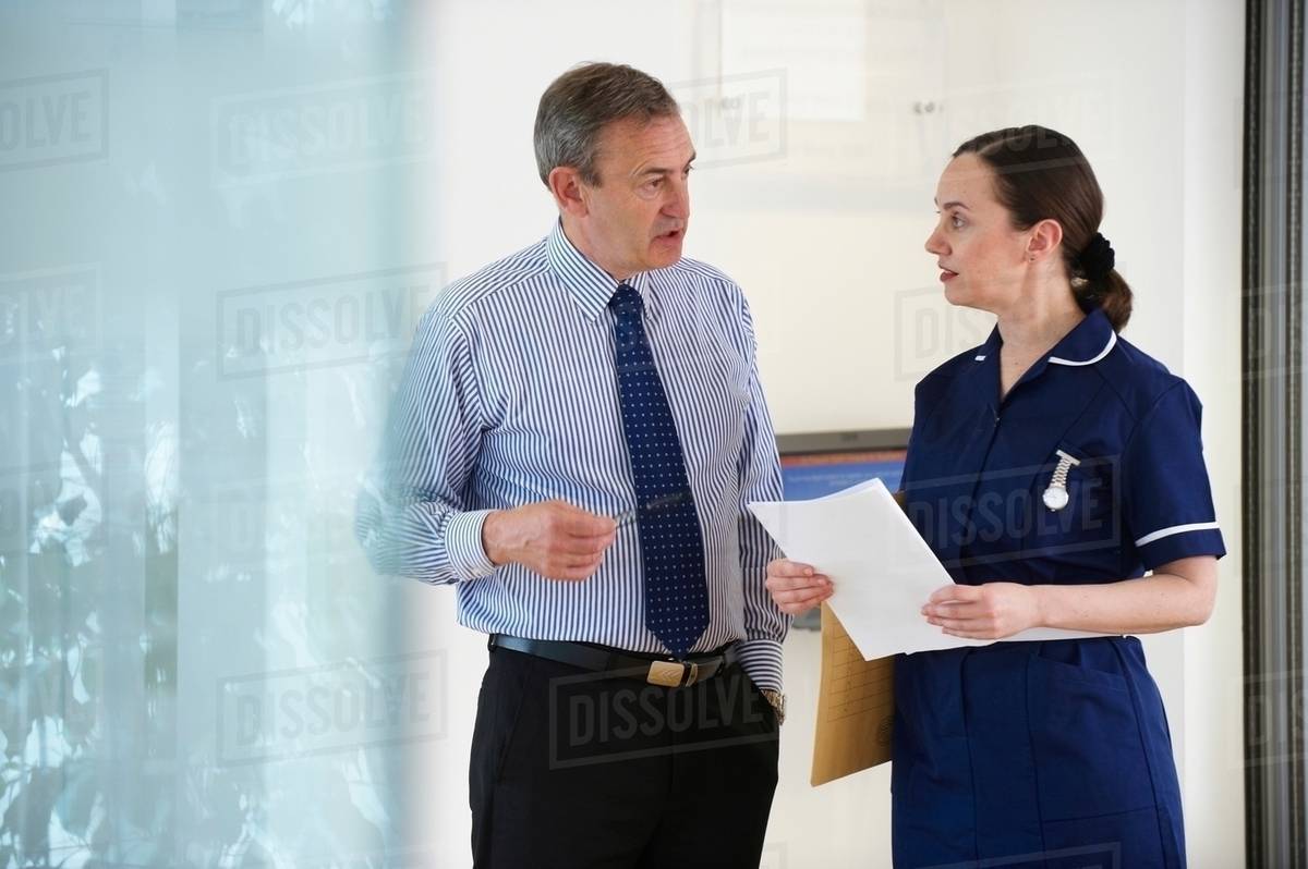 Nurse and Doctor talking in room - Royalty-free Stock Photo | Dissolve