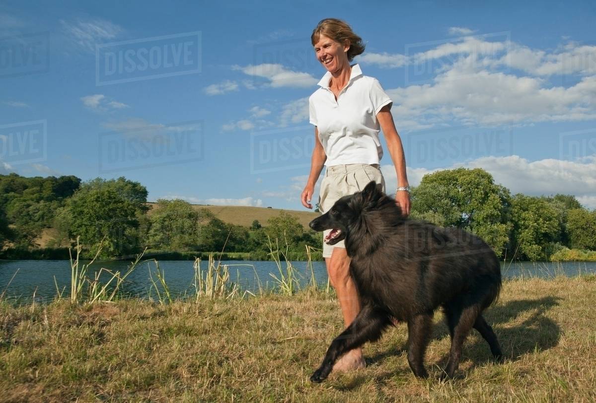 Woman walking with dog - Royalty-free Stock Photo | Dissolve