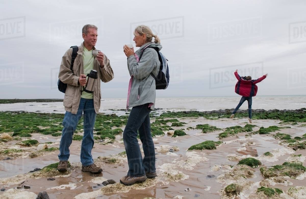 Seniors take a break on beach and child - Stock Photo - Dissolve