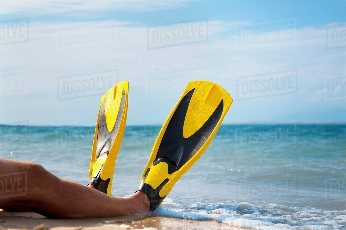 Man with flippers at the beach - Royalty-free Stock Photo | Dissolve