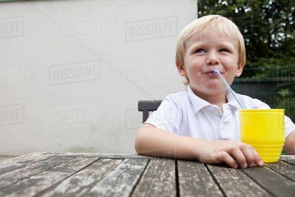 Young Boy trinking juice with a straw - Royalty-free Stock Photo | Dissolve