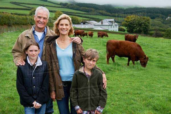 Family on farm in a field with cows - Royalty-free Stock Photo | Dissolve