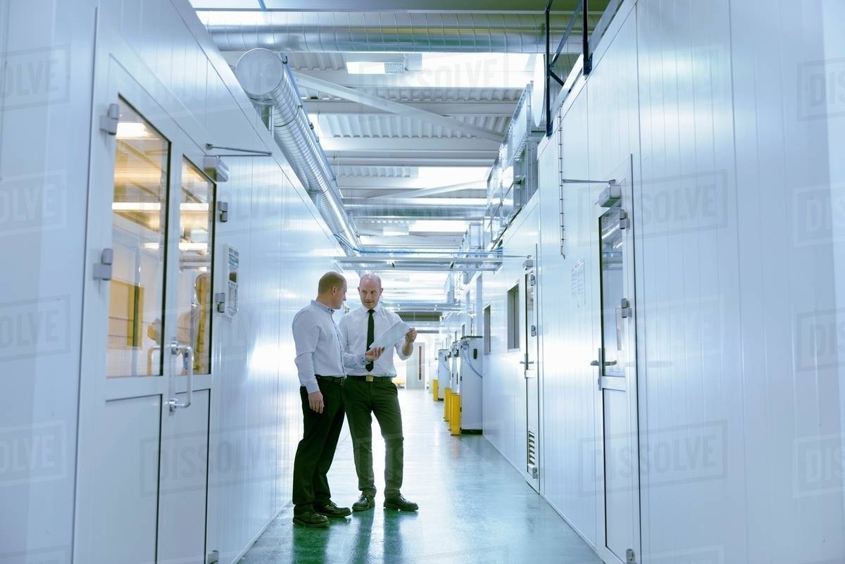 Managers inspecting robotic spray booths in automotive parts spray ...