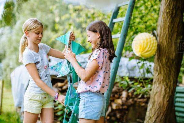 Girls decorating garden for summer party - Stock Photo - Dissolve