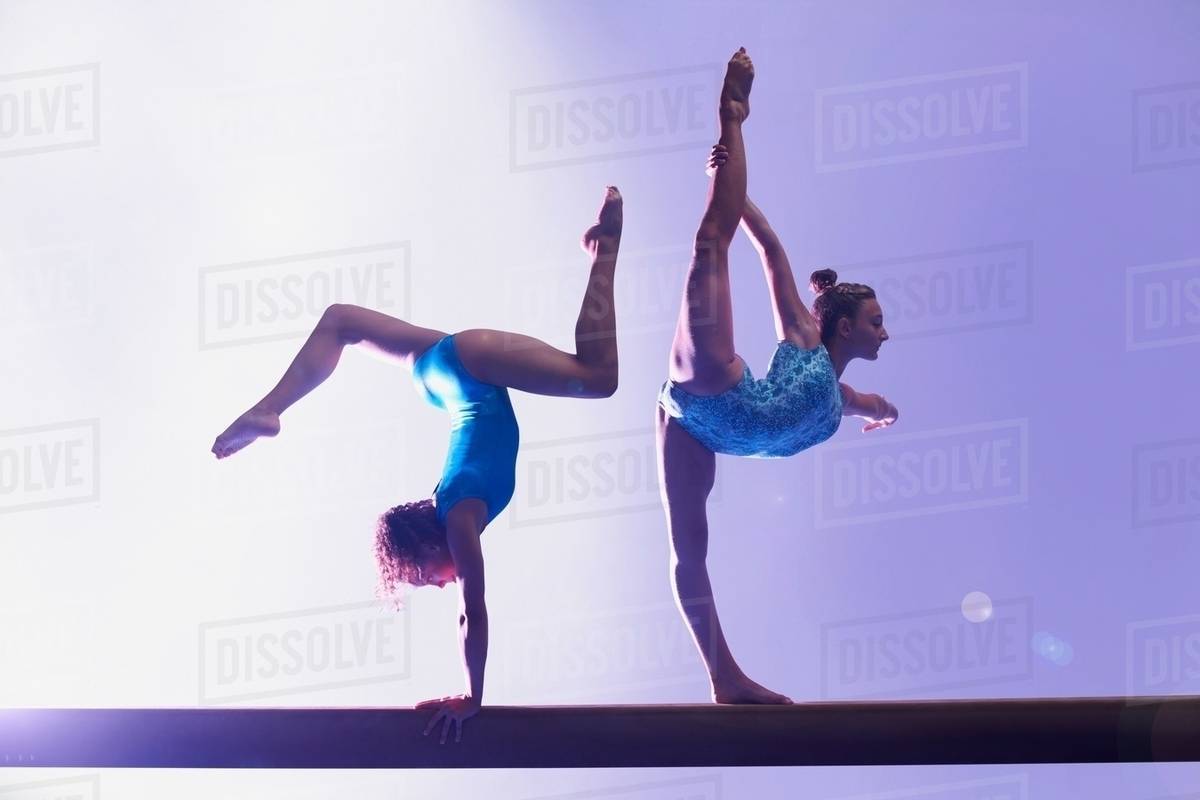 Gymnasts doing routine on bar - Royalty-free Stock Photo | Dissolve