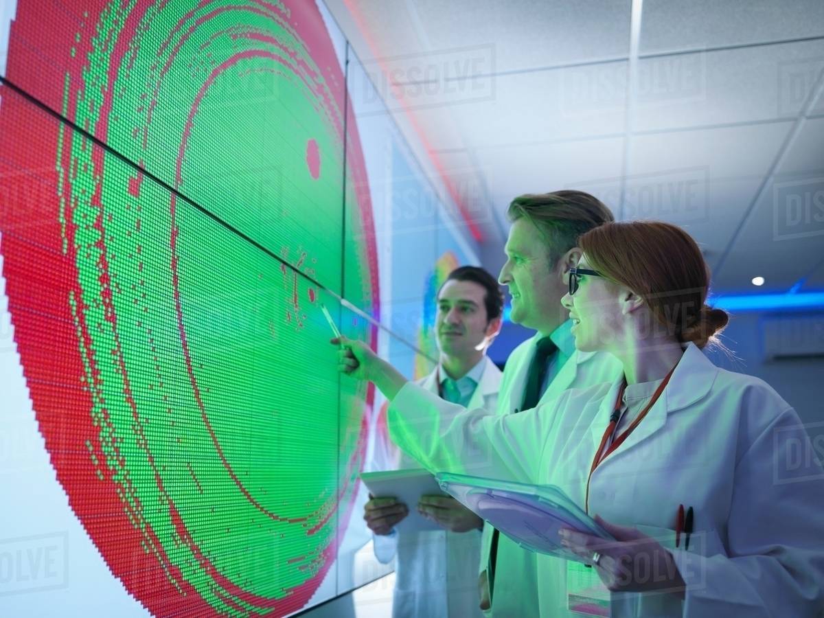 Scientists studying graphical display of silicon wafer on screens ...