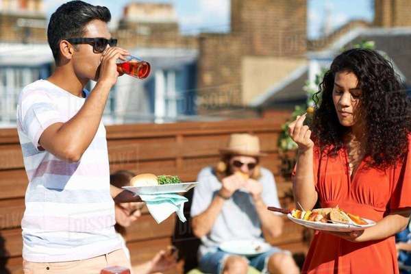 Friends eating party food and drinking at rooftop party - Royalty-free ...