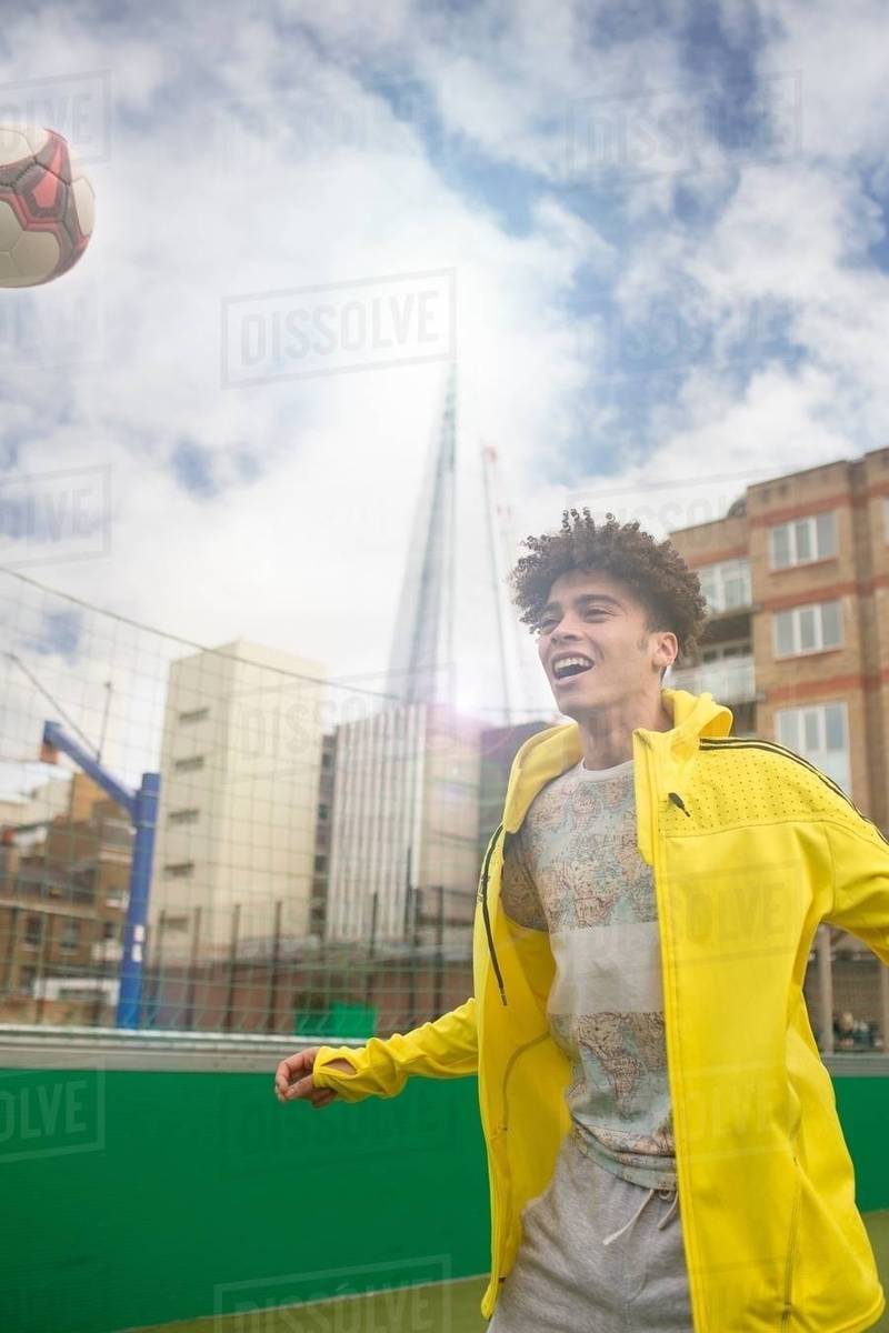 Young man playing football on urban football pitch - Royalty-free Stock ...