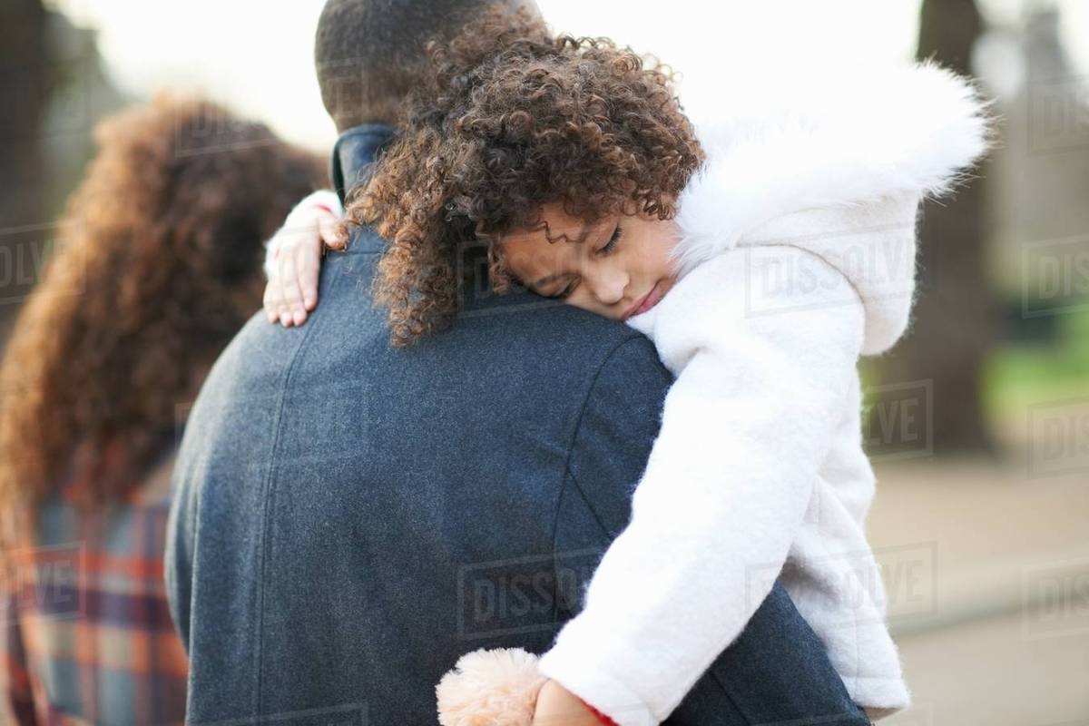 Rear view of father carrying sleeping daughter - Stock Photo - Dissolve