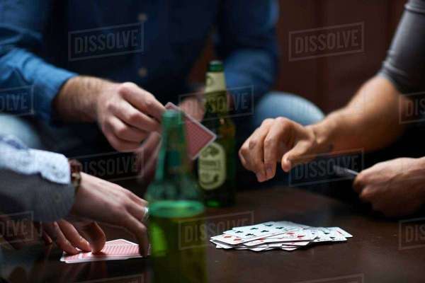 Hands of three men playing card game in traditional UK pub - Royalty ...