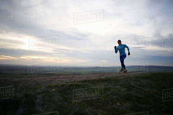 Full length view of fell runner running against dramatic sky - Stock ...